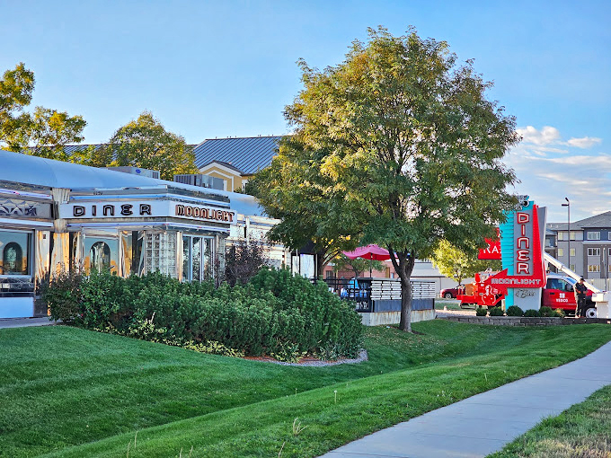 The Moonlight Diner stands proudly against Colorado's blue sky, its vintage sign and silver exterior a beacon for hungry travelers and locals seeking authentic Americana.