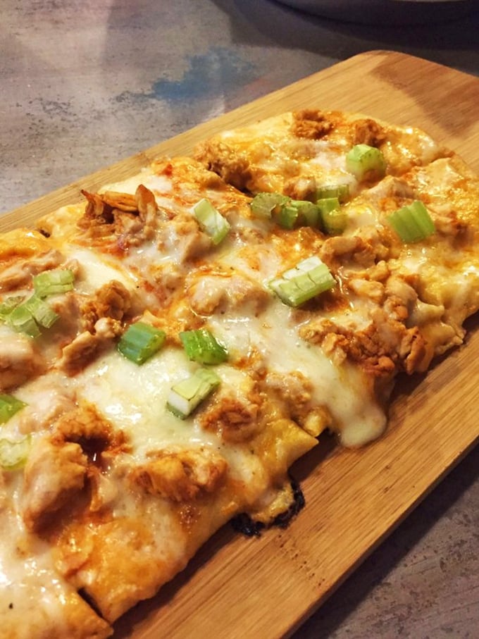 Flatbread that defies gravity with its mountain of toppings. A savory canvas painted with cheese, protein, and the perfect touch of green onion.