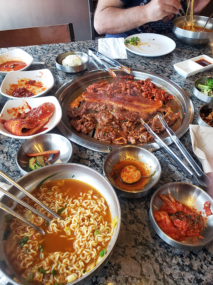 The table tells the whole story&mdash;marinated meats sizzling on the grill, ramen steaming in its bowl, and banchan filling every available inch.