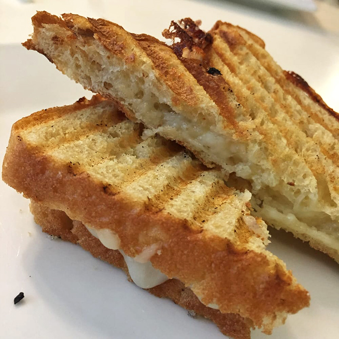 The humble grilled cheese, elevated to art form &ndash; where bread becomes golden canvas and cheese performs melty magic. 