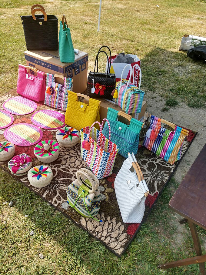 Hand-woven bags burst with color against the grass, like tropical flowers that can carry your wallet and keys with stylish efficiency.