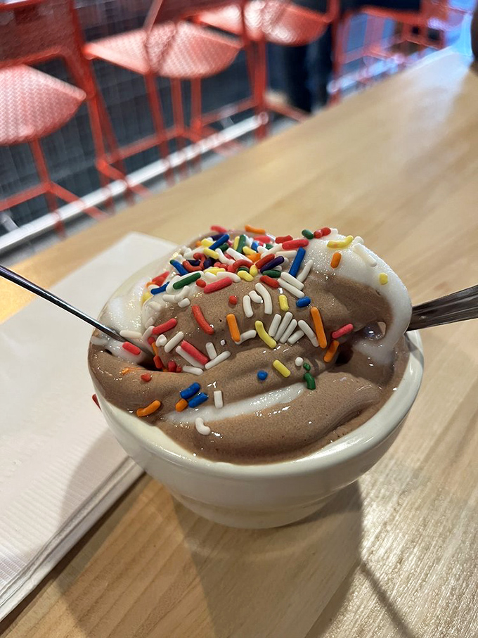Soft serve ice cream with rainbow sprinkles&mdash;proof that happiness can indeed be contained in a small white bowl.