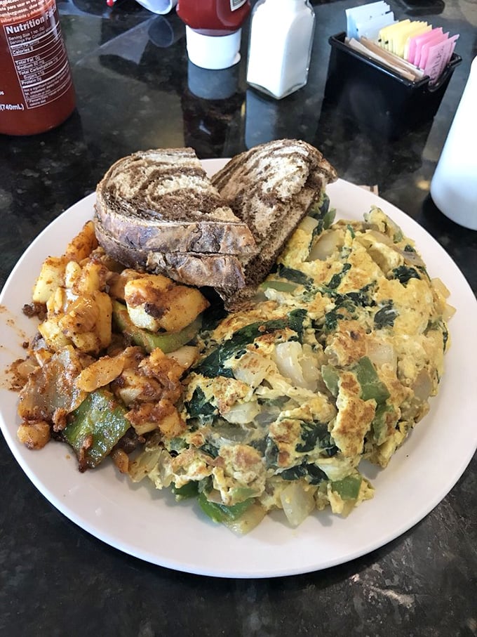 An omelet so perfectly executed it could make a French chef weep, alongside home fries that deserve their own zip code.