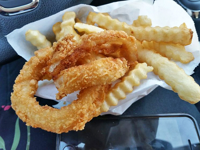 Golden onion rings that shatter at first bite, paired with crinkle-cut fries&mdash;a perfect marriage of texture that makes you forget vegetables ever grew in dirt.