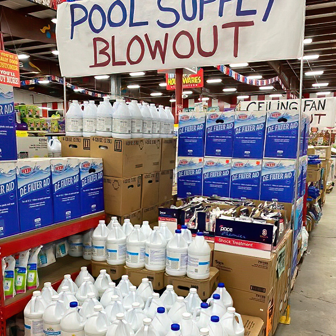 The "Pool Supply Blowout" sign hovers above chemical battalions ready to wage war against algae, proving that even seasonal items find their discount destiny at Ollie's.