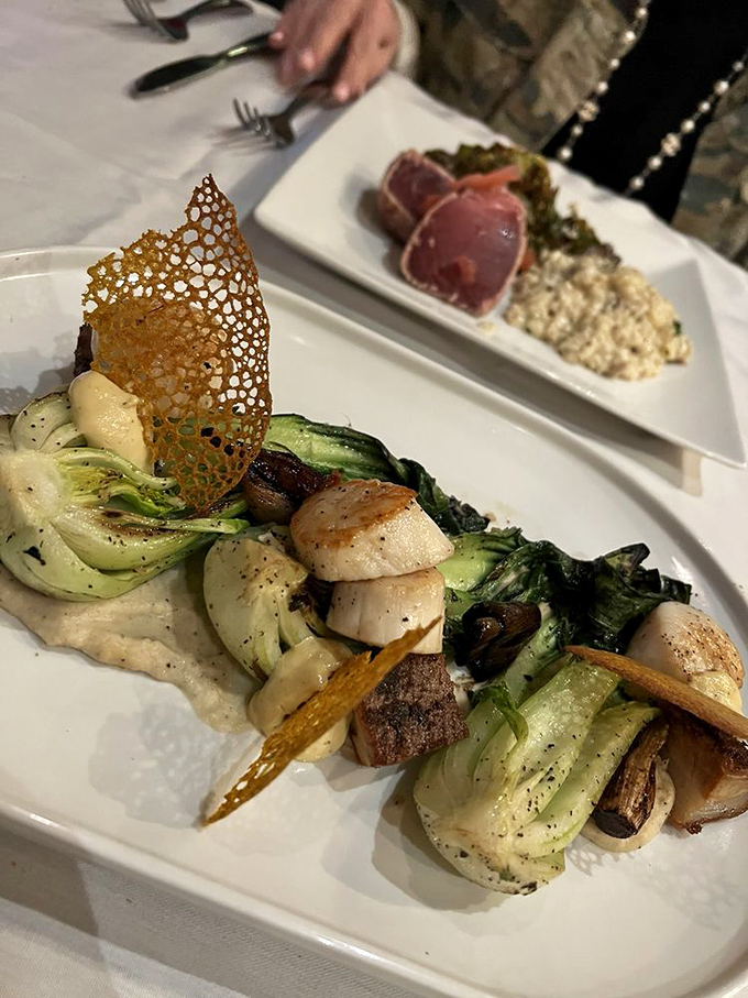 This scallop dish showcases the kitchen's artistry&mdash;perfectly seared medallions nestled among vegetables like jewels in a culinary crown.