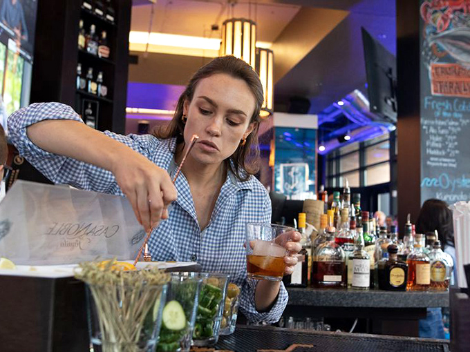 The art of mixology in motion. Behind the bar, craft cocktails come to life through skilled hands and quality ingredients that elevate the entire dining experience.