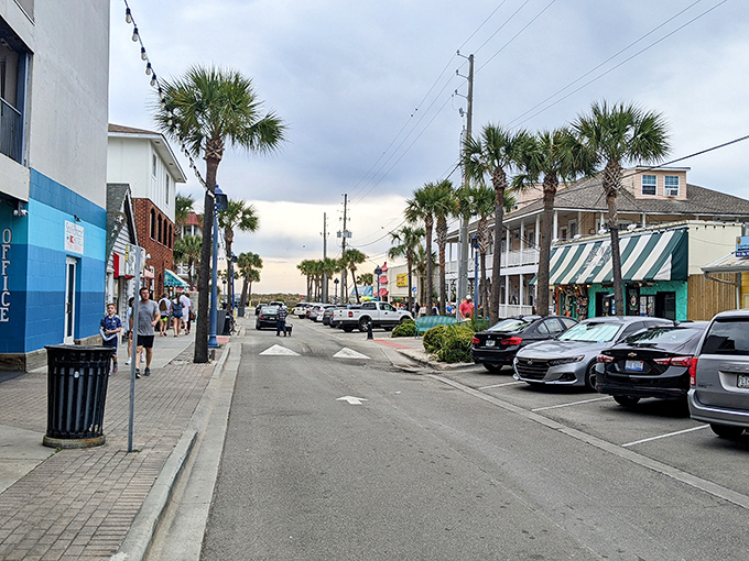 Tybee Island's main drag, where palm trees stand sentinel and every storefront promises coastal treasures. Bernie's green awning beckons just down the way.
