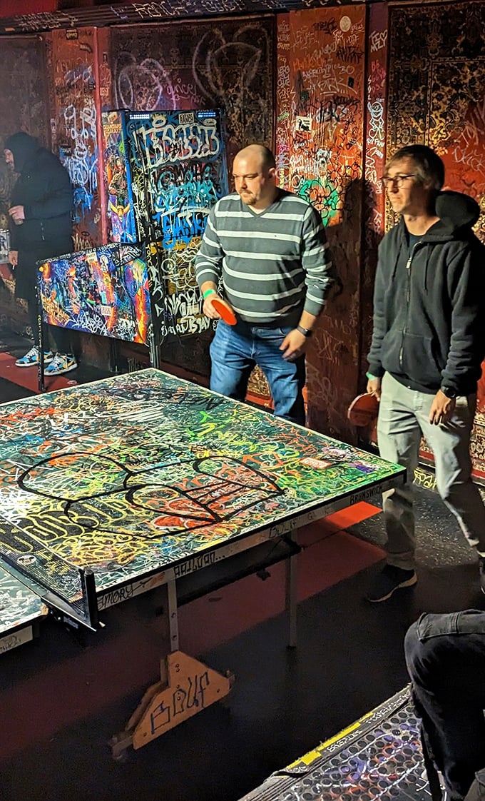 The exterior at night becomes a neon beacon for those seeking refuge from chain restaurants and places where the bartender asks about your "flavor profile."