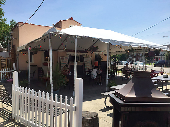 Alamo BBQ's outdoor tent seating beckons like a barbecue oasis. White picket fence included &ndash; because good manners matter even when sauce is dripping down your chin.