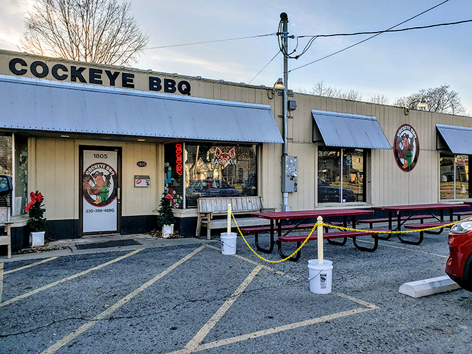 The humble exterior of Cockeye BBQ hides a smoky paradise within. Blue awnings and picnic tables promise a no-nonsense barbecue experience.