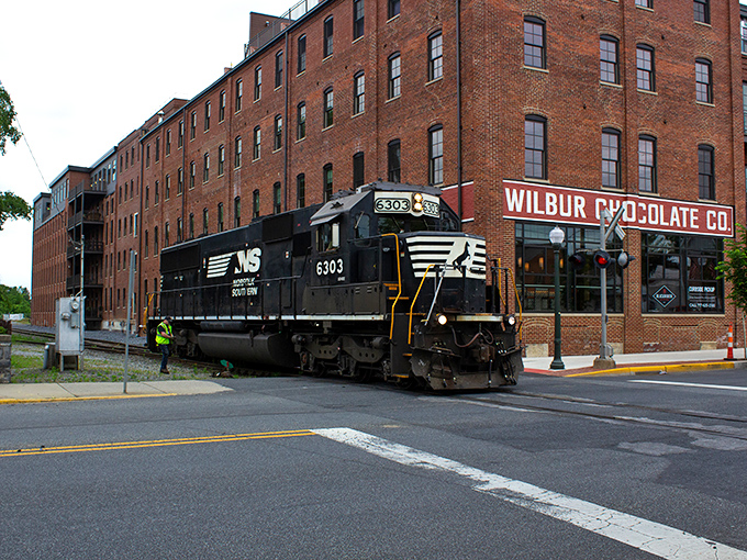 The historic Wilbur Chocolate factory stands proudly as a Norfolk Southern train rumbles past &ndash; sweet and steel in perfect harmony.