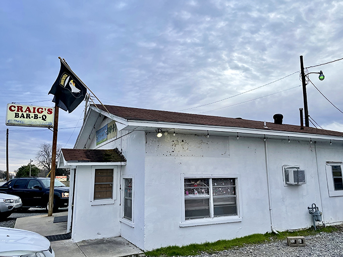 That weathered sign and simple building? Nature's way of telling you the real artistry happens inside Craig's smokers.