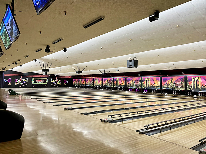 Polished lanes stretch toward infinity under cosmic lighting, promising the sweet satisfaction of a perfect strike or the comedy of a gutter ball.