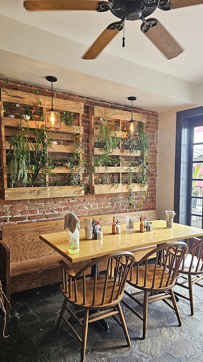 Exposed brick meets living greenery in this cozy dining space. The wooden tables invite you to settle in for a morning feast worth savoring.