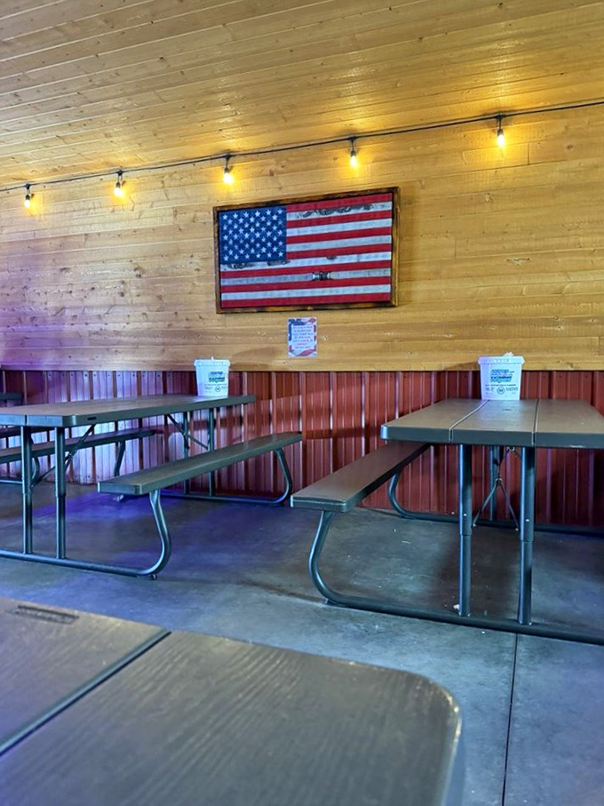 Simple wooden benches under Old Glory &ndash; no fancy tablecloths needed when the food does all the talking.