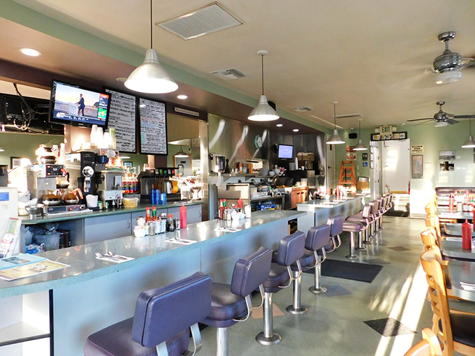 Classic diner counter seating&mdash;where the breakfast magic happens. Those purple swivel stools have witnessed more morning revelations than a therapist's couch.