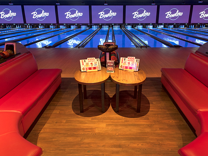Plush red couches and gleaming blue lanes create the perfect setting for friendly competition, where comfort meets classic American recreation.
