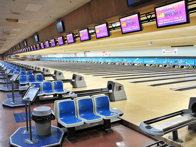 Rows of gleaming lanes stretch toward bowling infinity, where blue chairs have witnessed decades of triumph and friendly trash talk.