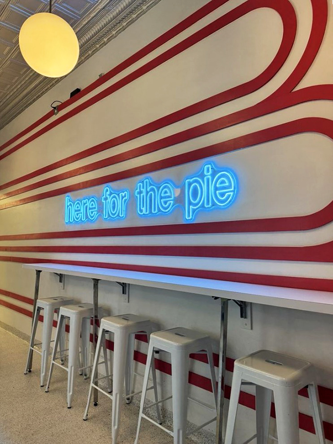 The "here for the pie" neon sign speaks the absolute truth. These red and white stripes aren't just decor&mdash;they're racing stripes for your taste buds.