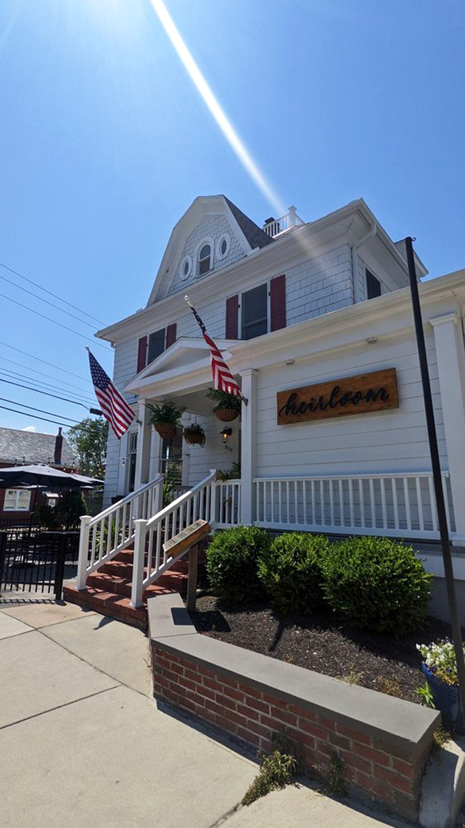 Heirloom's unassuming Victorian exterior belies the culinary magic happening inside. This white clapboard house with its American flag and neat porch practically whispers "come taste something wonderful."