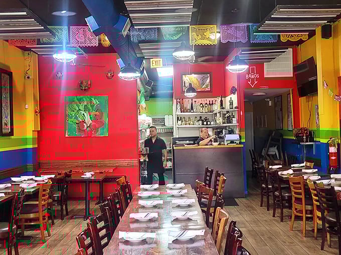 Vibrant walls in primary colors create a fiesta atmosphere inside 5 Rabanitos, where papel picado banners dance overhead like permanent party decorations.