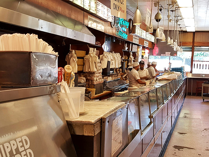 The counter where magic happens. These skilled meat artisans have likely sliced more pastrami in a day than most people will eat in a lifetime.