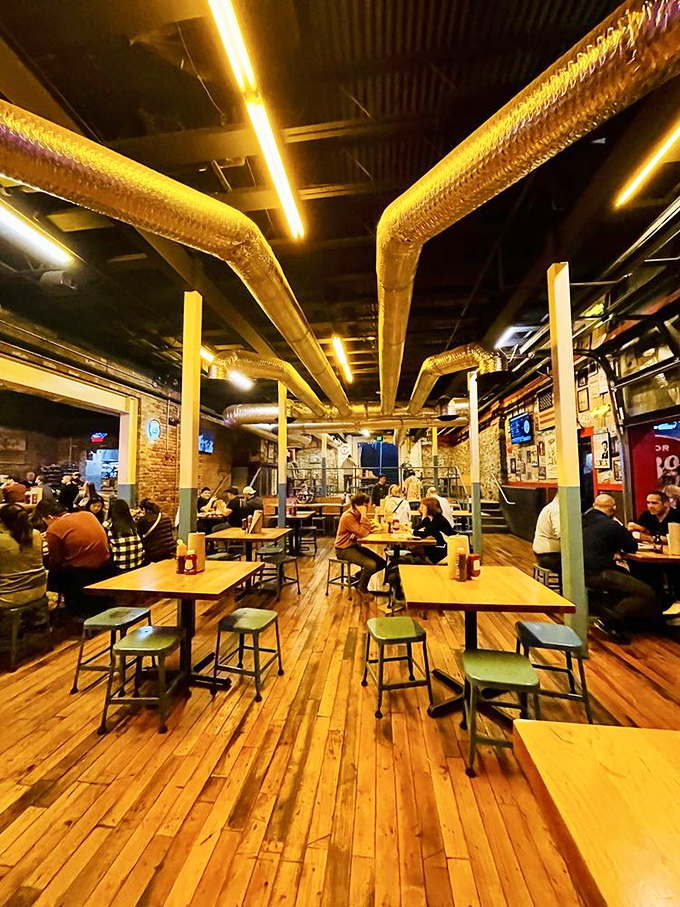 Inside, wooden floors and exposed ductwork create a temple of barbecue authenticity where conversations flow as freely as the sweet tea.