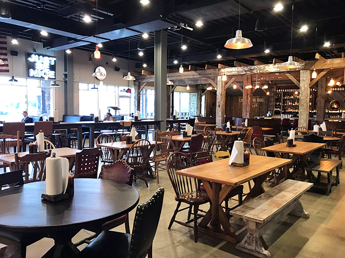 Inside, rustic meets refined with weathered beams, mismatched chairs, and pendant lighting creating the perfect backdrop for serious meat consumption.