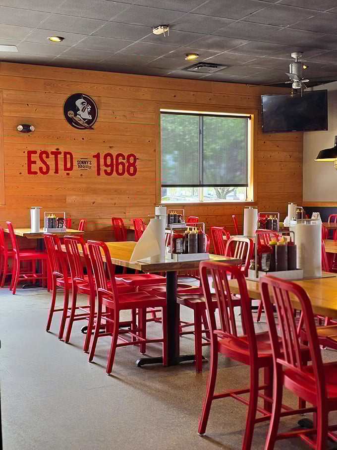 Red chairs pop against honey-colored wood walls, creating a space that says, "Slow down, friend—good barbecue can't be rushed."