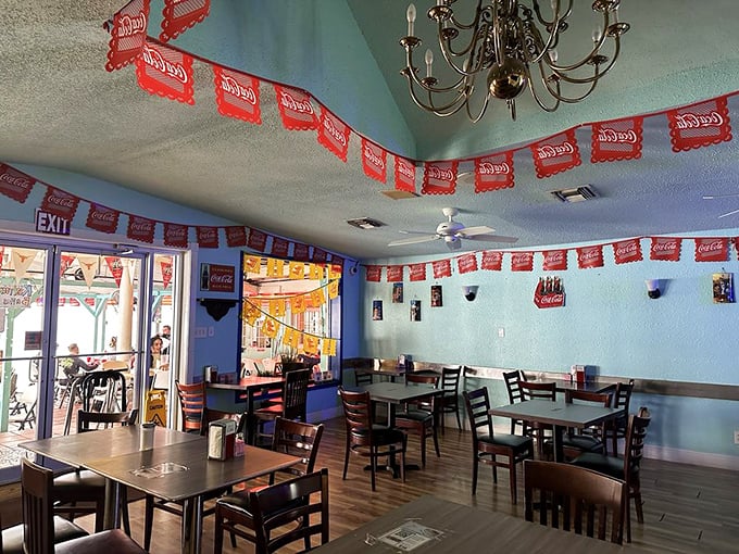 Coca-Cola banners dance across light blue walls while a chandelier adds unexpected charm. This dining room has witnessed countless breakfast epiphanies and taco-induced joy.