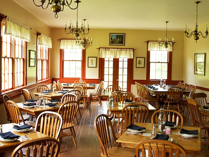 Windsor chairs and wooden tables bathe in natural light, creating a dining room where history and hospitality have shared the same address for nearly two centuries.
