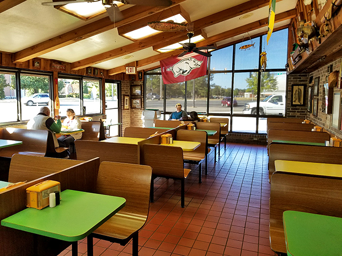 Wooden booths, colorful tabletops, and Razorback pride create the perfect backdrop for burger bliss. Simple, honest, and utterly Arkansas.