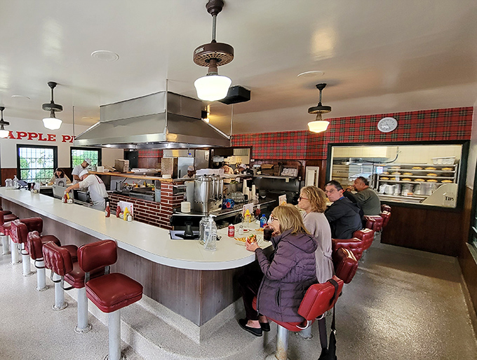 Inside, the horseshoe counter wraps diners around the action, where red vinyl stools have witnessed decades of first dates and family traditions.