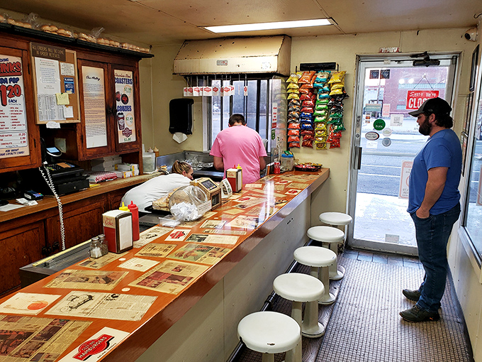 Six stools, one counter, and a century of burger history. This tiny space has served more Kansas legends than the state capitol.