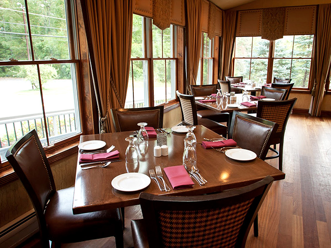 Warm wood tones and burgundy accents create the perfect backdrop for memorable meals. Like a well-tailored suit, this dining room knows comfort never goes out of style. 