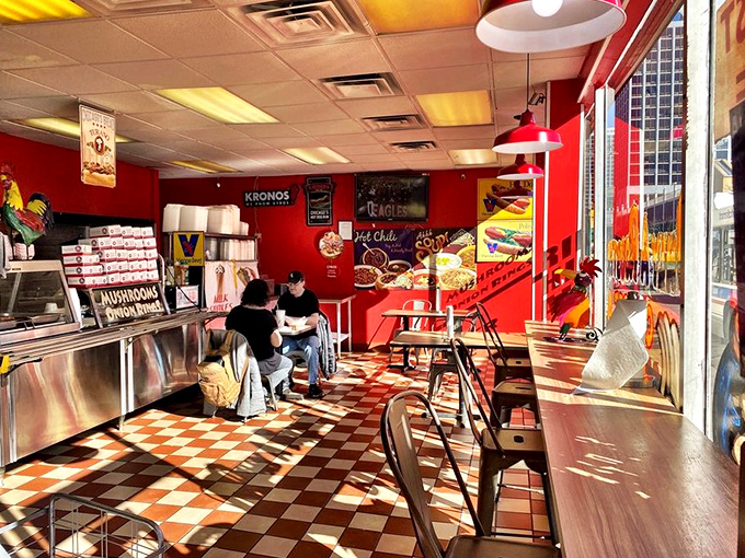 The red walls and checkerboard floor aren't just retro charm—they're the unofficial uniform of authentic Chicago hot dog joints.