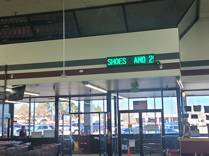 Green digital signs hover above like retail constellations, guiding shoppers through this vast universe of secondhand possibilities.