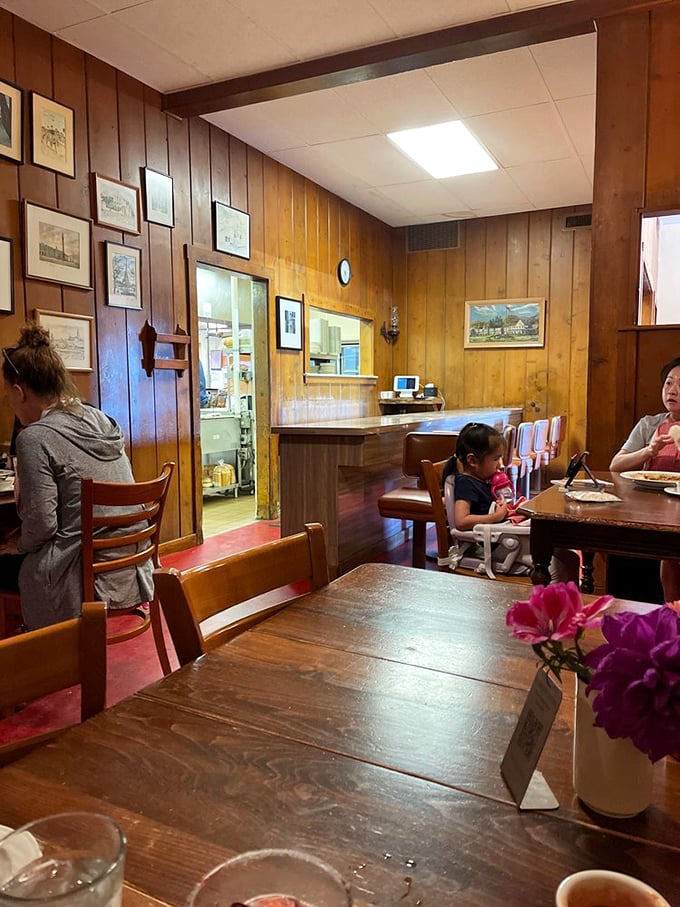Wood-paneled walls tell silent stories of decades past as families gather around sturdy tables that have supported countless memorable meals.