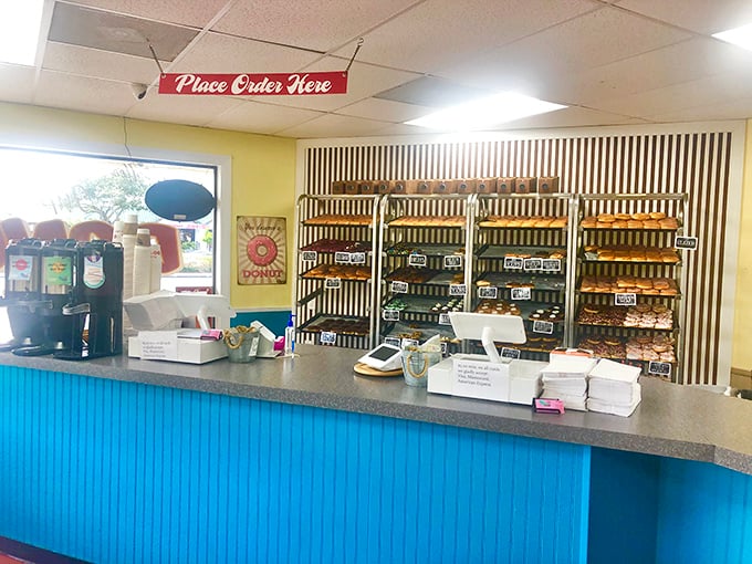 The blue counter and black-and-white striped wall create a retro vibe that says, "Serious donut business happens here." No pretension, just passion.