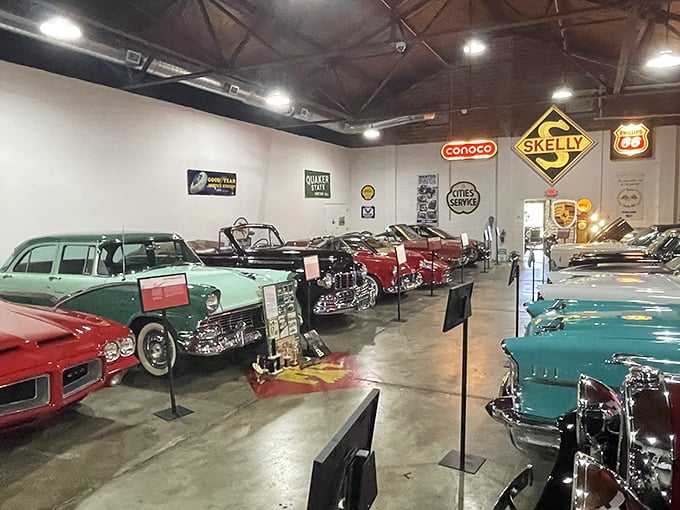 Chrome dreams line up in perfect formation, each vehicle telling its own American road story under the watchful gaze of vintage gas station signs.