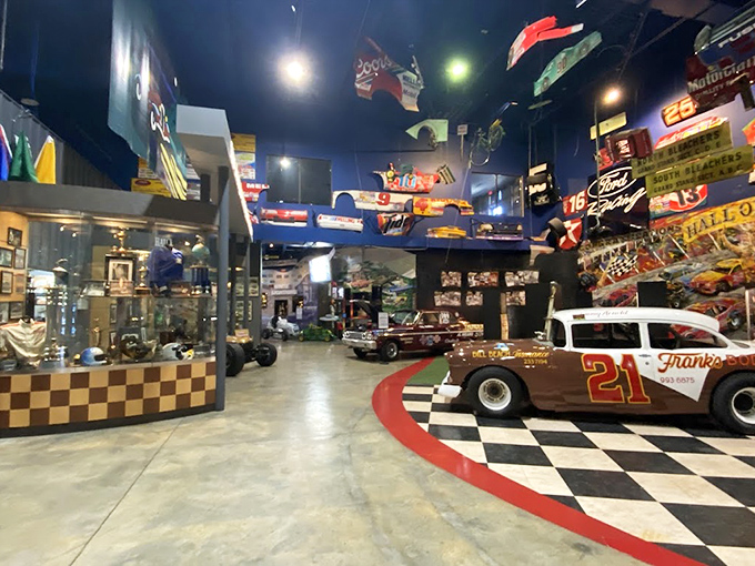 Racing history explodes across the walls in vibrant color. Like a stock car cathedral, the space honors mechanical saints whose thundering engines once rattled the Georgia pines.