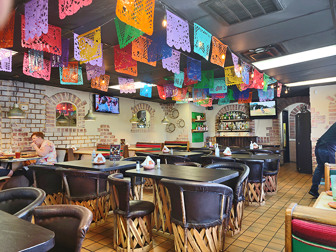 Colorful papel picado banners create a festive canopy above traditional equipale chairs, setting the perfect stage for the flavor fiesta to come.