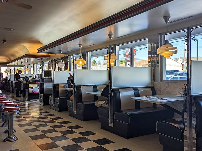 Classic black and white checkerboard floors meet cherry-red accents in this time capsule where calories don't count and nostalgia comes complimentary.