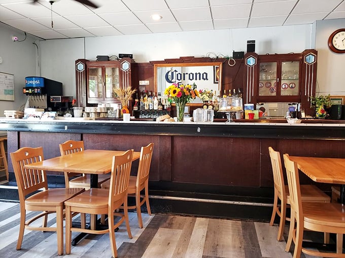 The warm wooden bar area feels like it's been welcoming neighbors for generations, where Corona signs glow and conversations flow freely.
