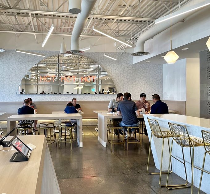 Modern, airy interiors with geometric patterns and communal seating create the perfect backdrop for chicken-induced euphoria. The "HOT CHICKEN" sign isn't just decor&mdash;it's a promise.