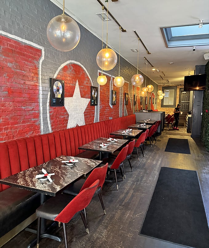 The interior's red banquettes and star-studded wall art create a vibe that's equal parts music studio and comfort food sanctuary.