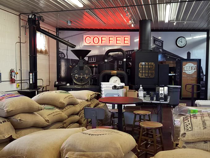 Coffee alchemy in action! The roasting operation takes center stage, surrounded by burlap sacks of beans waiting for their moment of transformation.