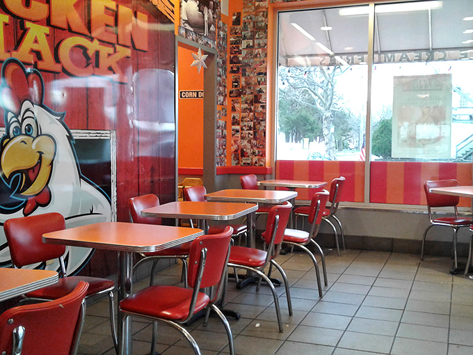 Retro chrome tables and cherry-red chairs transport you to simpler times, while the cartoon chicken mascot seems to wink knowingly.
