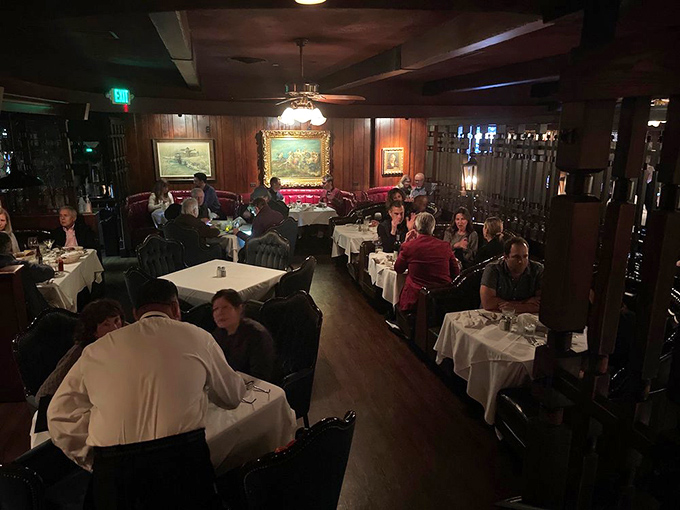 Step inside and time stands still. Dark wood paneling, white tablecloths, and red leather booths create the steakhouse atmosphere that modern restaurants try desperately to replicate.